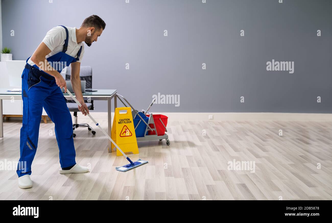 Man With Mop And Wet Floor Sign Stock Photo - Alamy