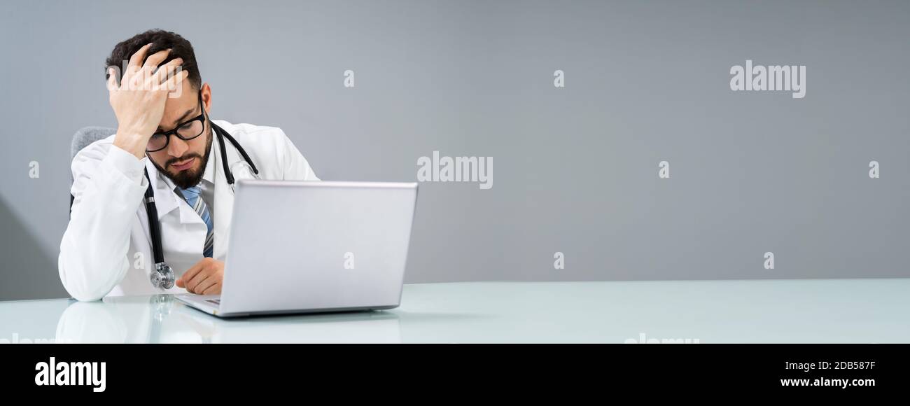 Sad Young Male Doctor Sitting In Clinic Stock Photo - Alamy