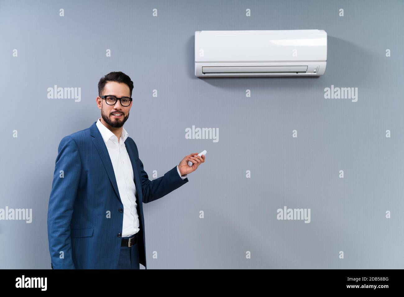 Portrait Of A Man Operating Air Conditioner With Remote Controller ...