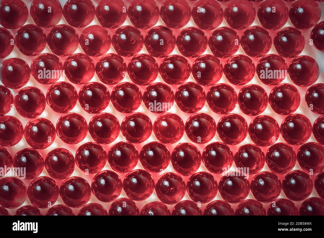 Red capsules on a white background close-up Stock Photo - Alamy