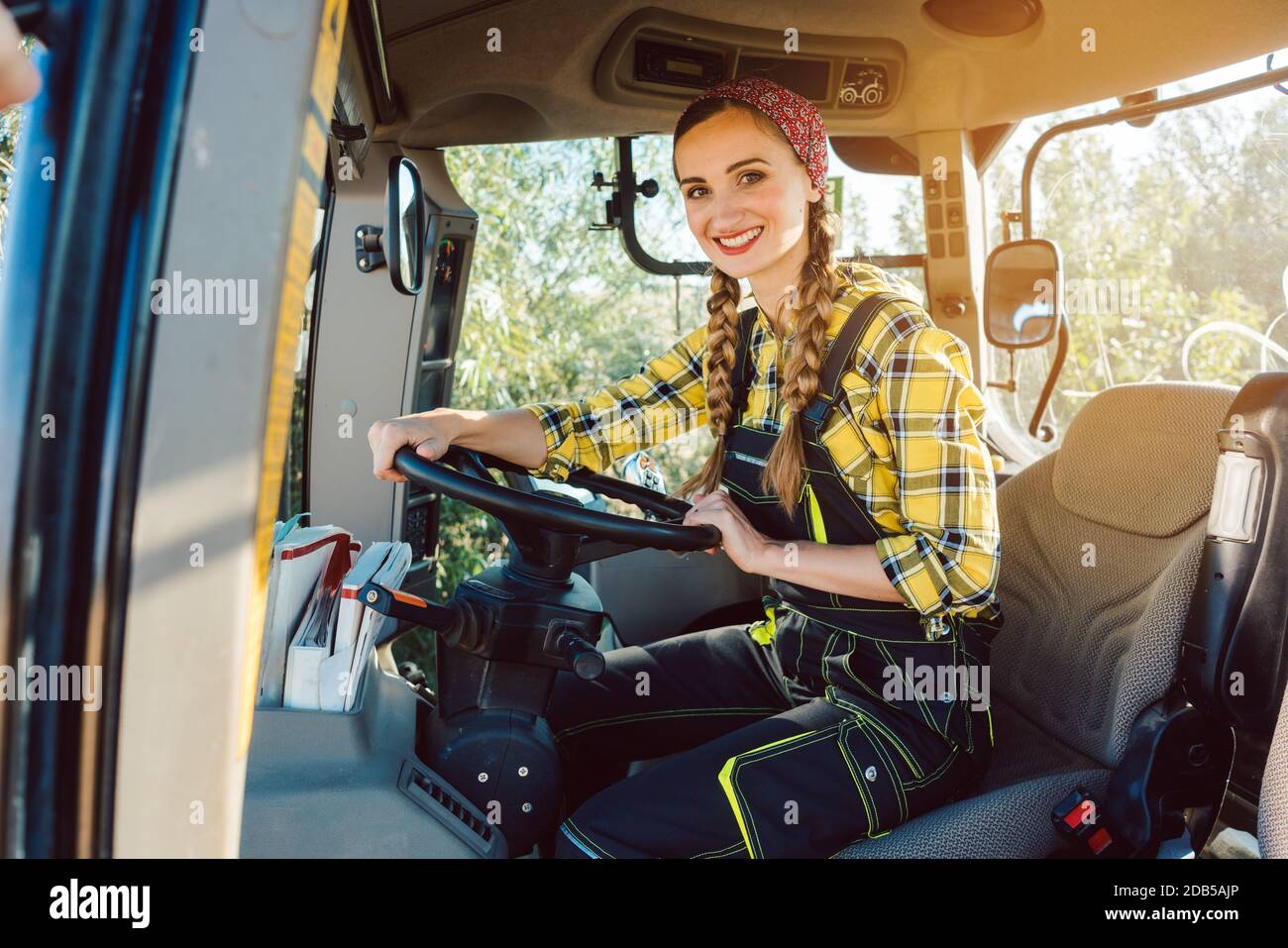 Farmer woman driving a tractor on the field to the harvest Stock Photo ...