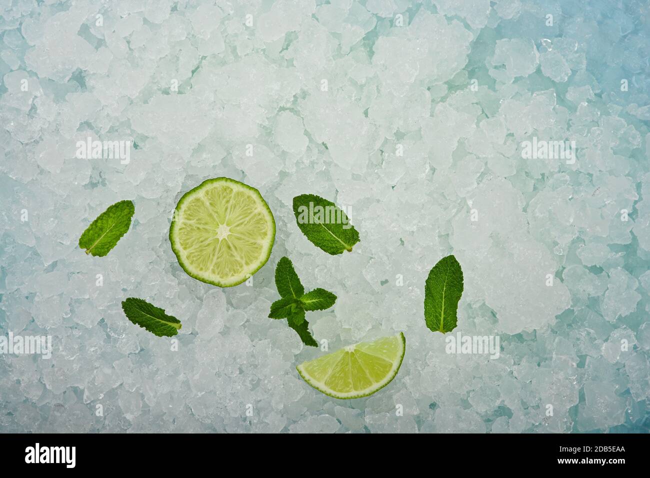 Close up fresh juicy green lime cut half and wedge slice and mint ...