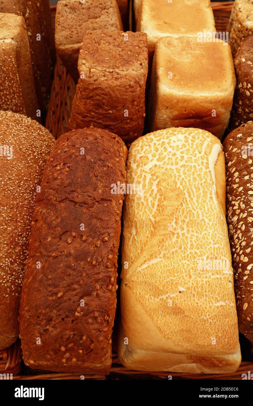 Close up selection of assorted fresh bread loaves on retail display of ...