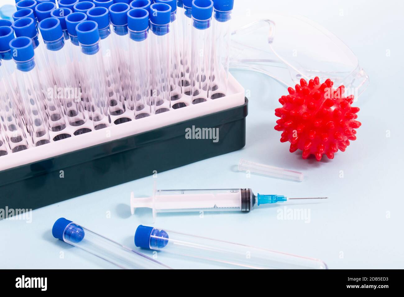 Several laboratory objects including syringe, vial rack, testing tubes ...