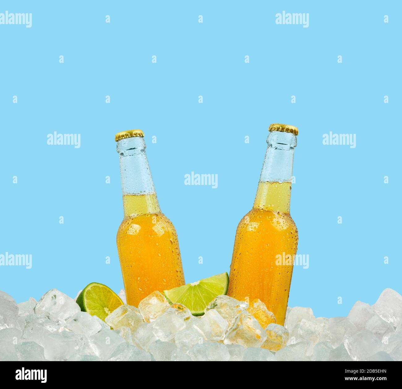 Close up two clear glass bottles of cold lager beer on ice cubes at ...