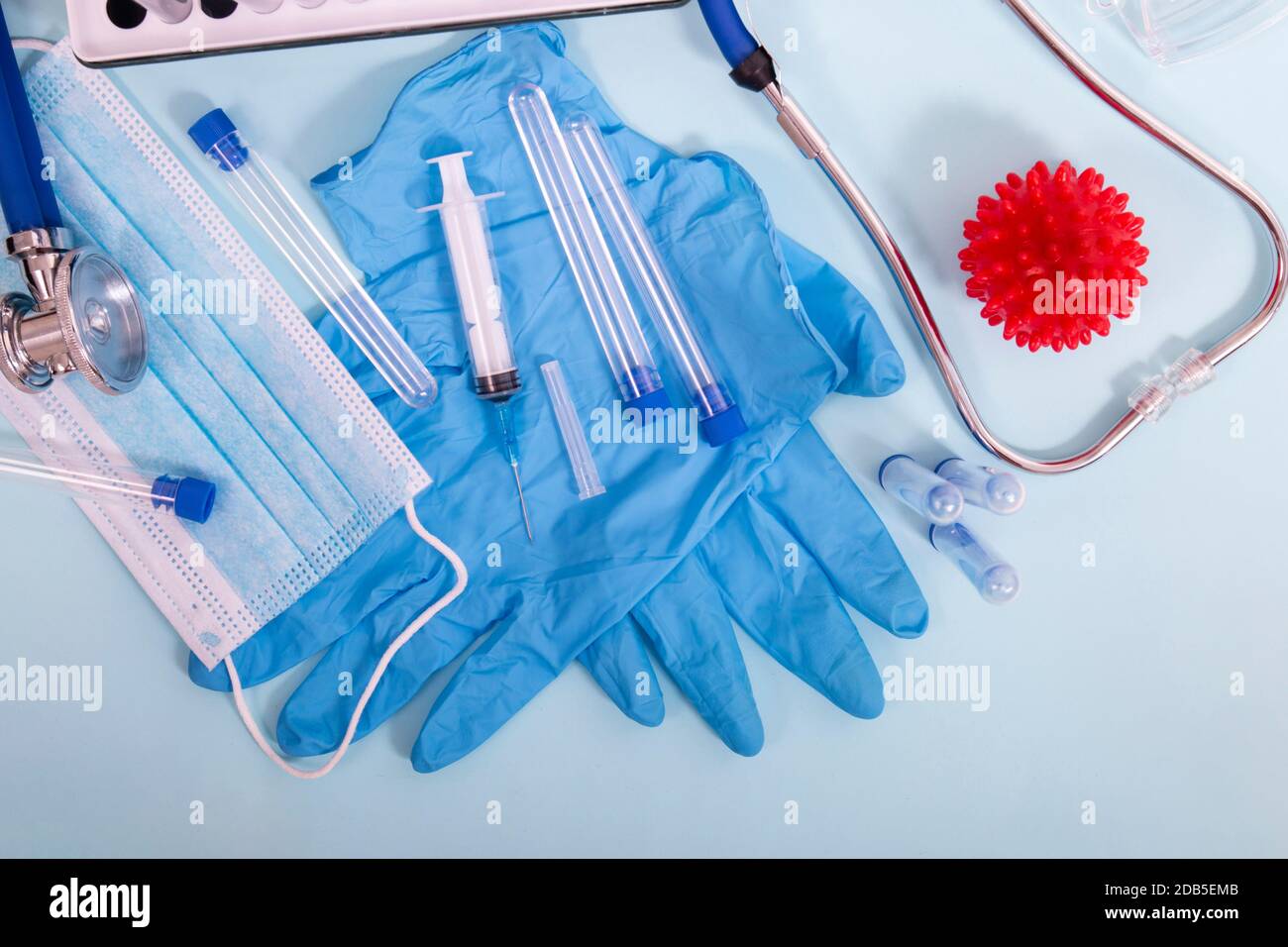 Several laboratory objects including protective mask, gloves, vial rack ...