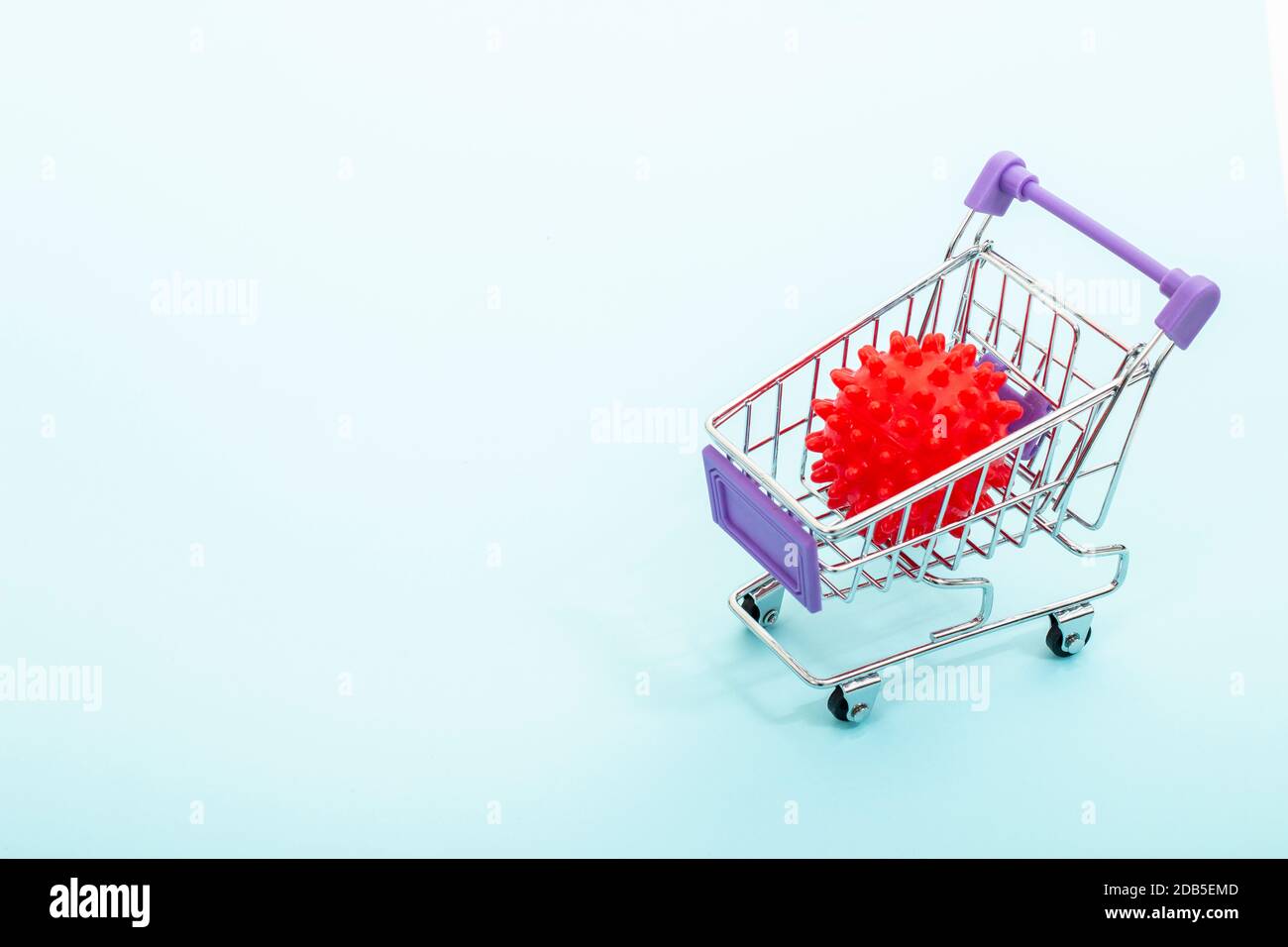 Virus in a miniature shopping cart isolated on a light blue background ...