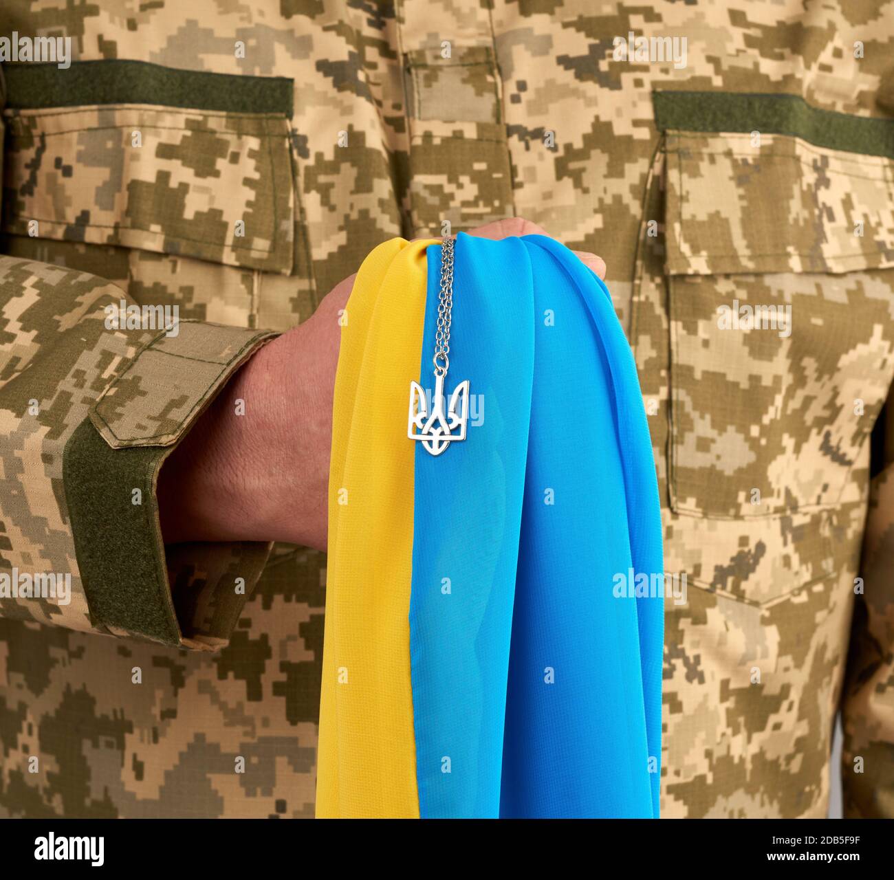 Ukrainian man warrior dressed in a military pixel uniform holds the ...