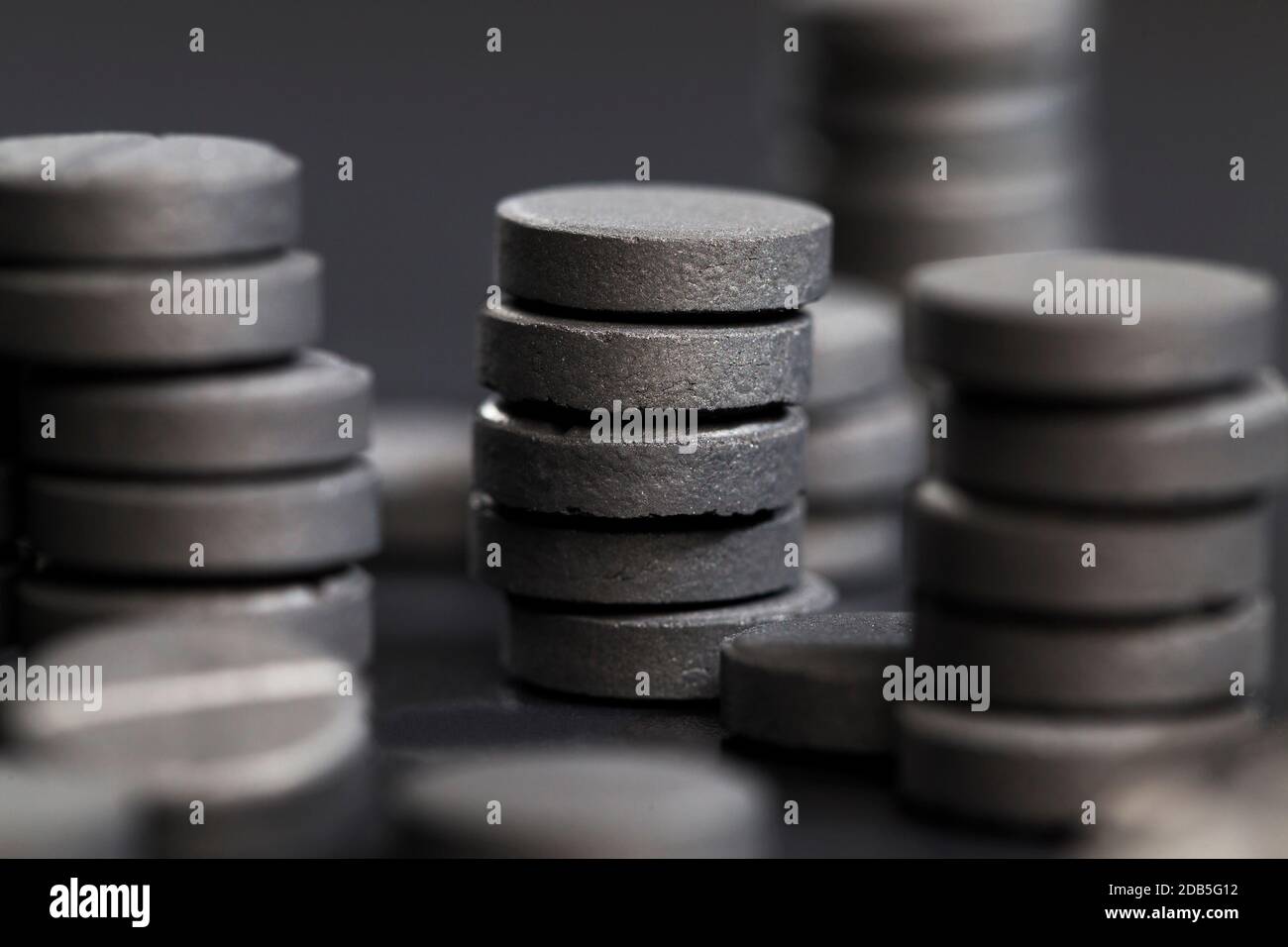 black pills medical drugs, close-up of identical drugs stacked in a ...