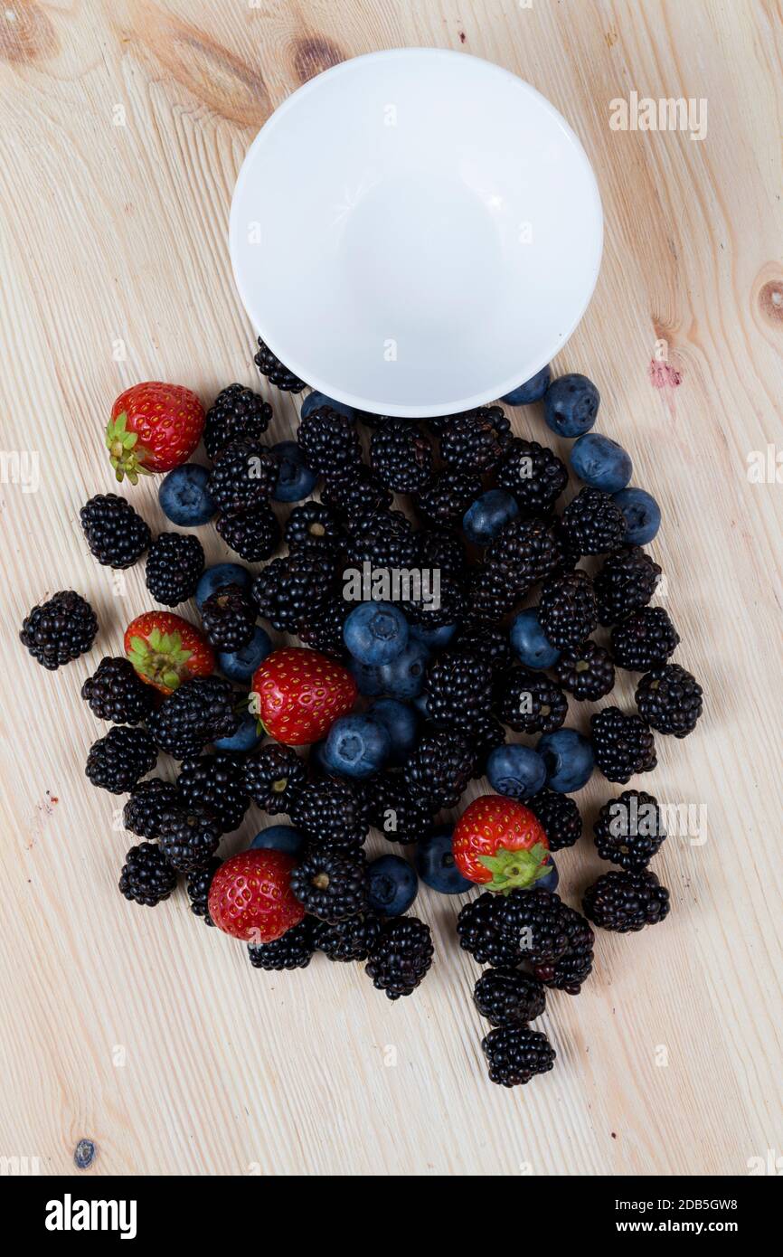 strawberries, blueberries and blackberries lie together after receiving ...