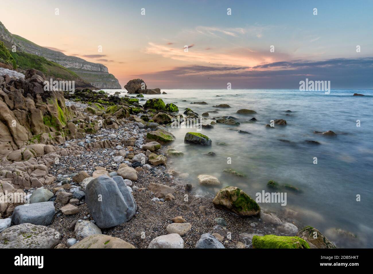 Orange vibrant summer sunset over rocky coastline at Llandudno in North ...