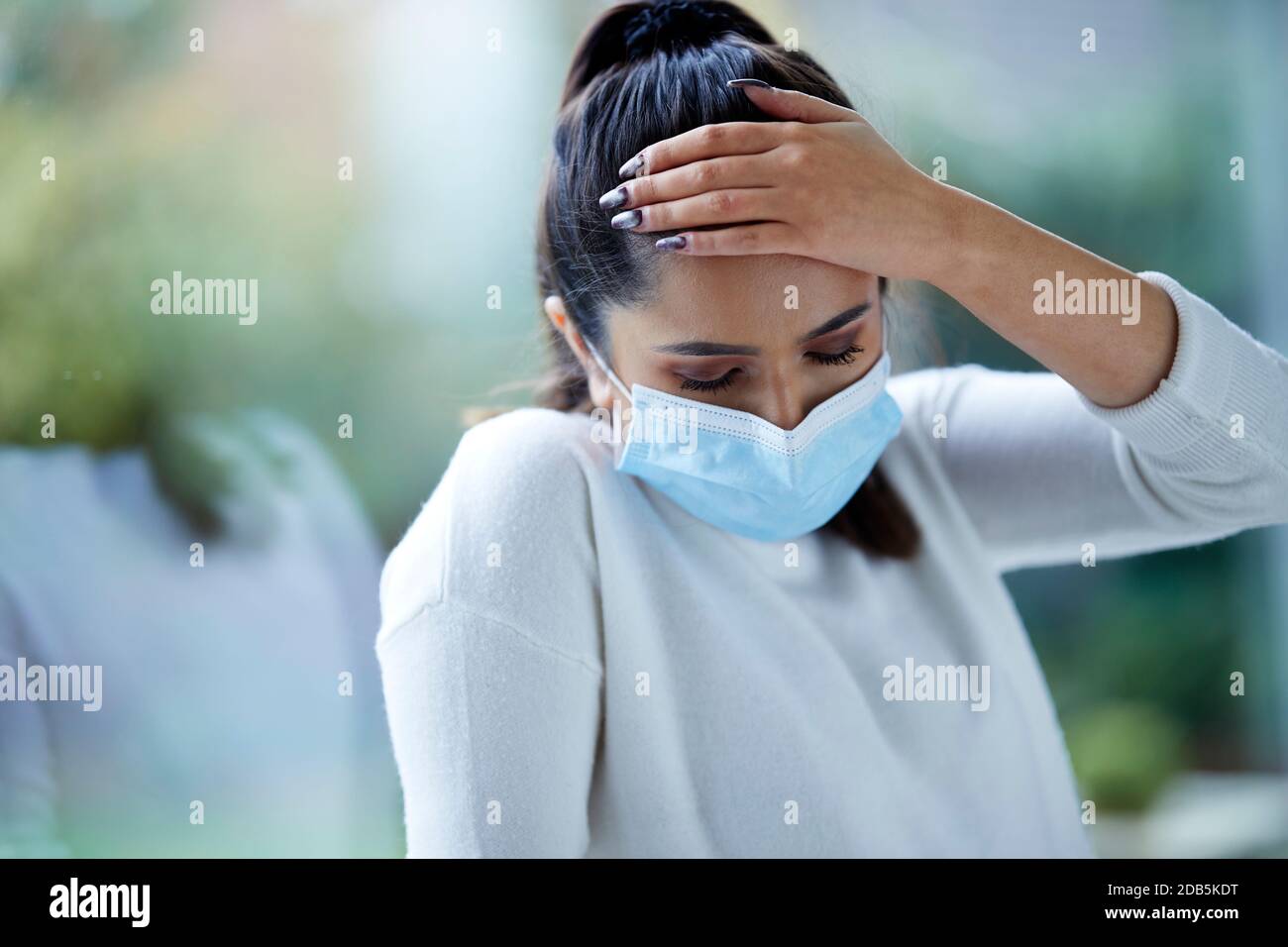 Woman wearing mask indoors coughing Stock Photo - Alamy