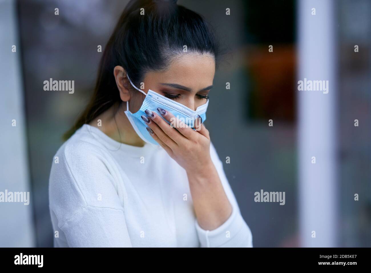 Woman wearing mask indoors coughing Stock Photo - Alamy