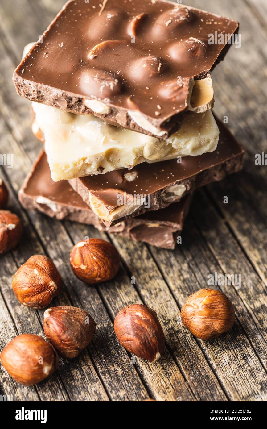 Dark nut chocolate and hazelnuts. Broken chocolate bar on black kitchen ...