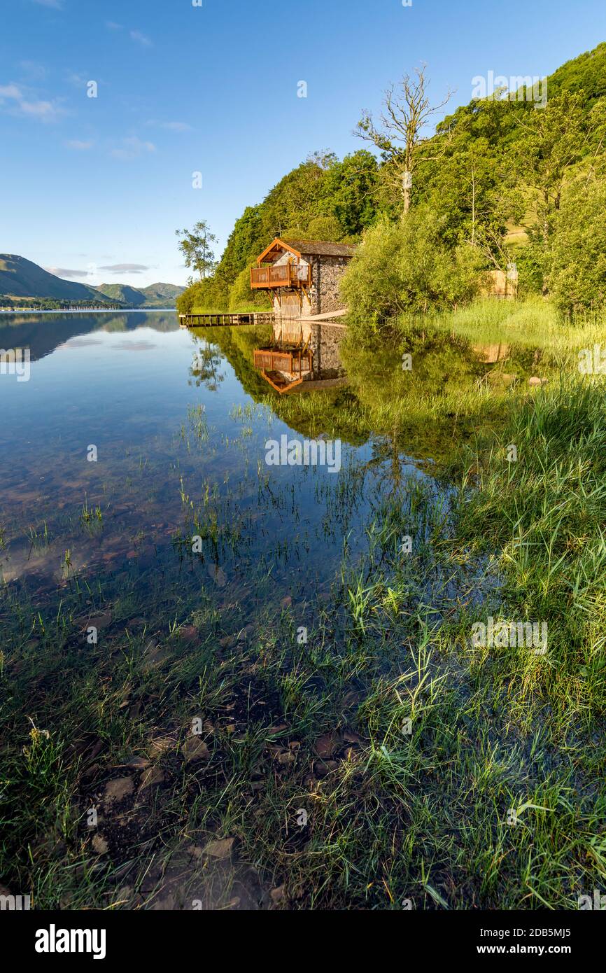 Ullswater Boathouse with clear calm reflections in lake on summer ...