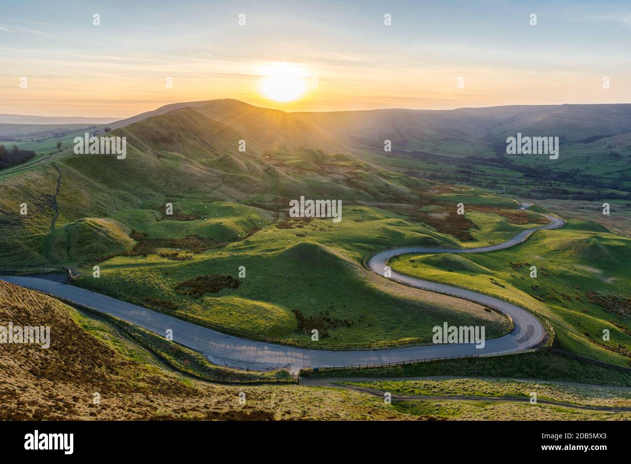 Sunset at Mam Tor in the Peak District with long winding road leading ...