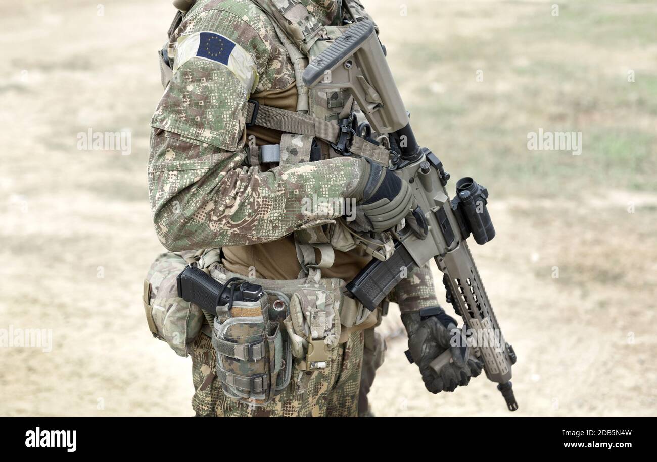 Soldier with assault rifle and flag of Europe on military uniform ...