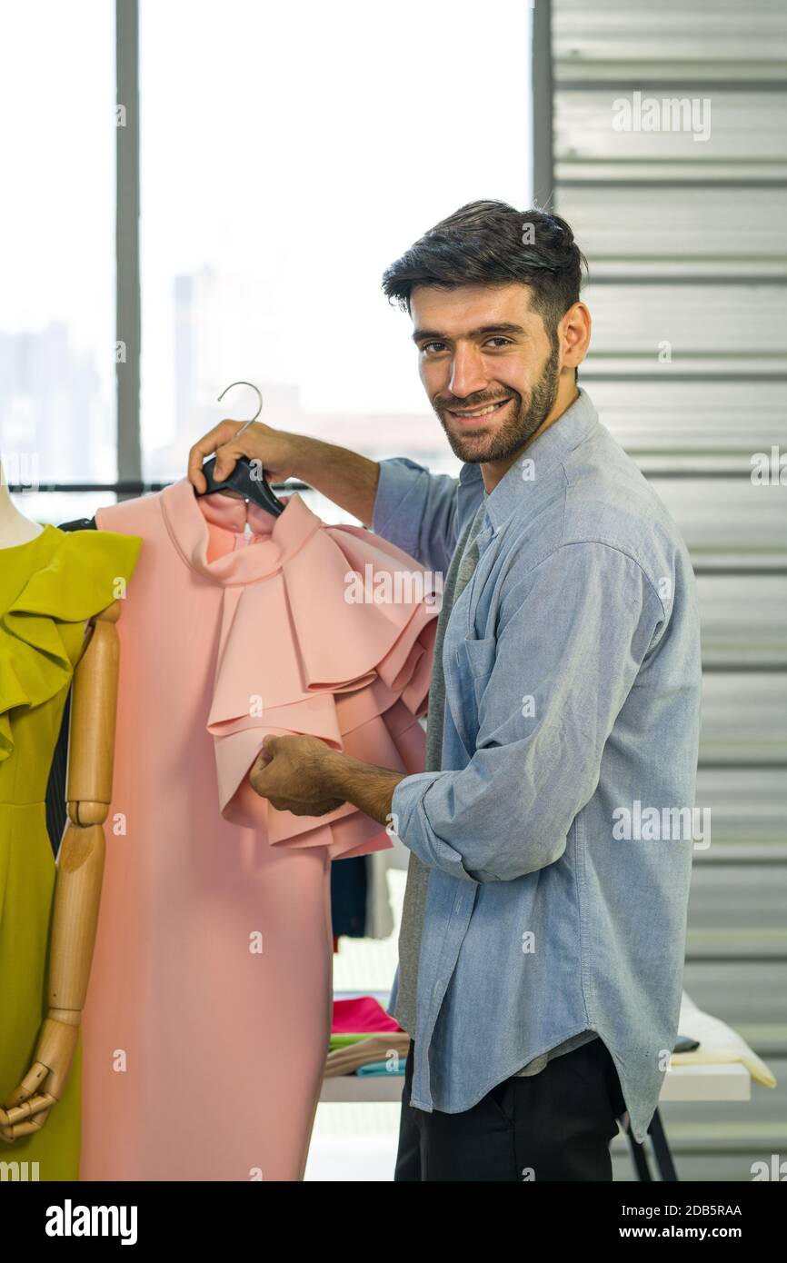 Fashion designer room. The men's dressmaker is arranging the dresses in ...