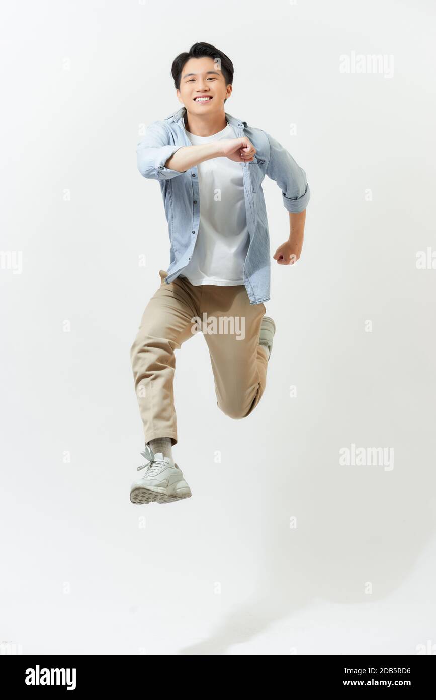 Young handsome Asian man smiling and jumping in mid-air Stock Photo - Alamy