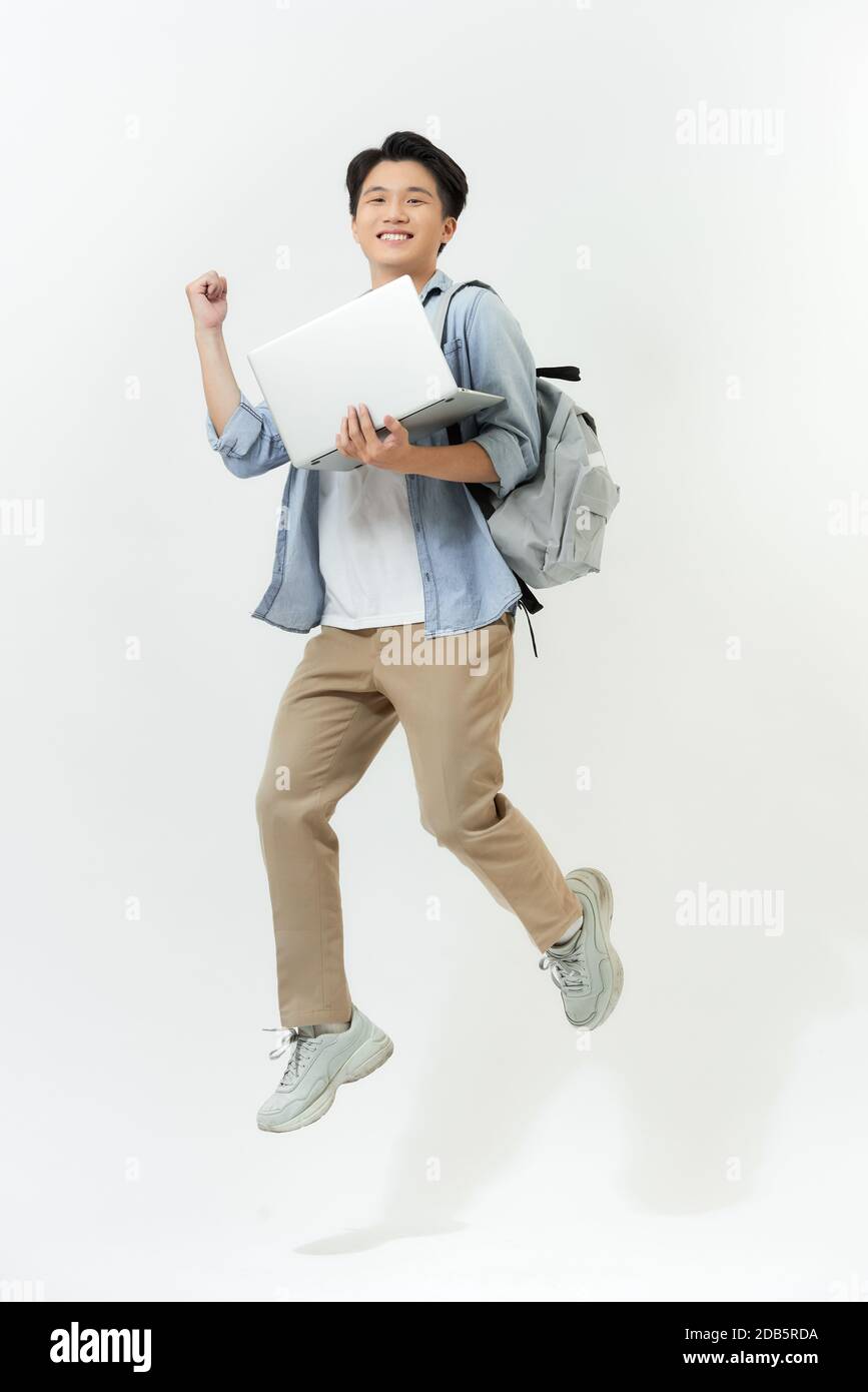 Jumping male Asian programmer with laptop on white background Stock ...