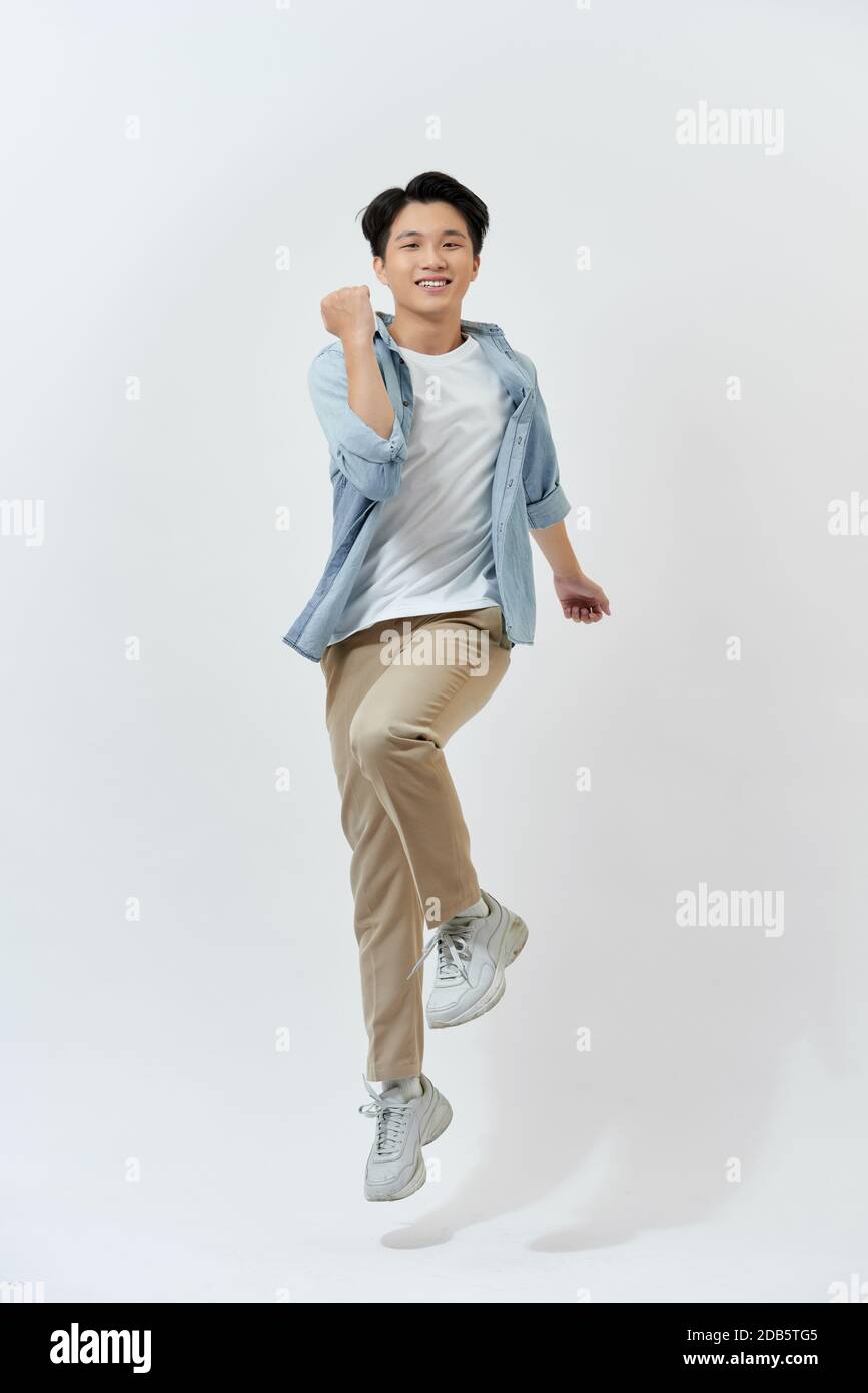 Young Asian man jumping in the air on white background Stock Photo - Alamy
