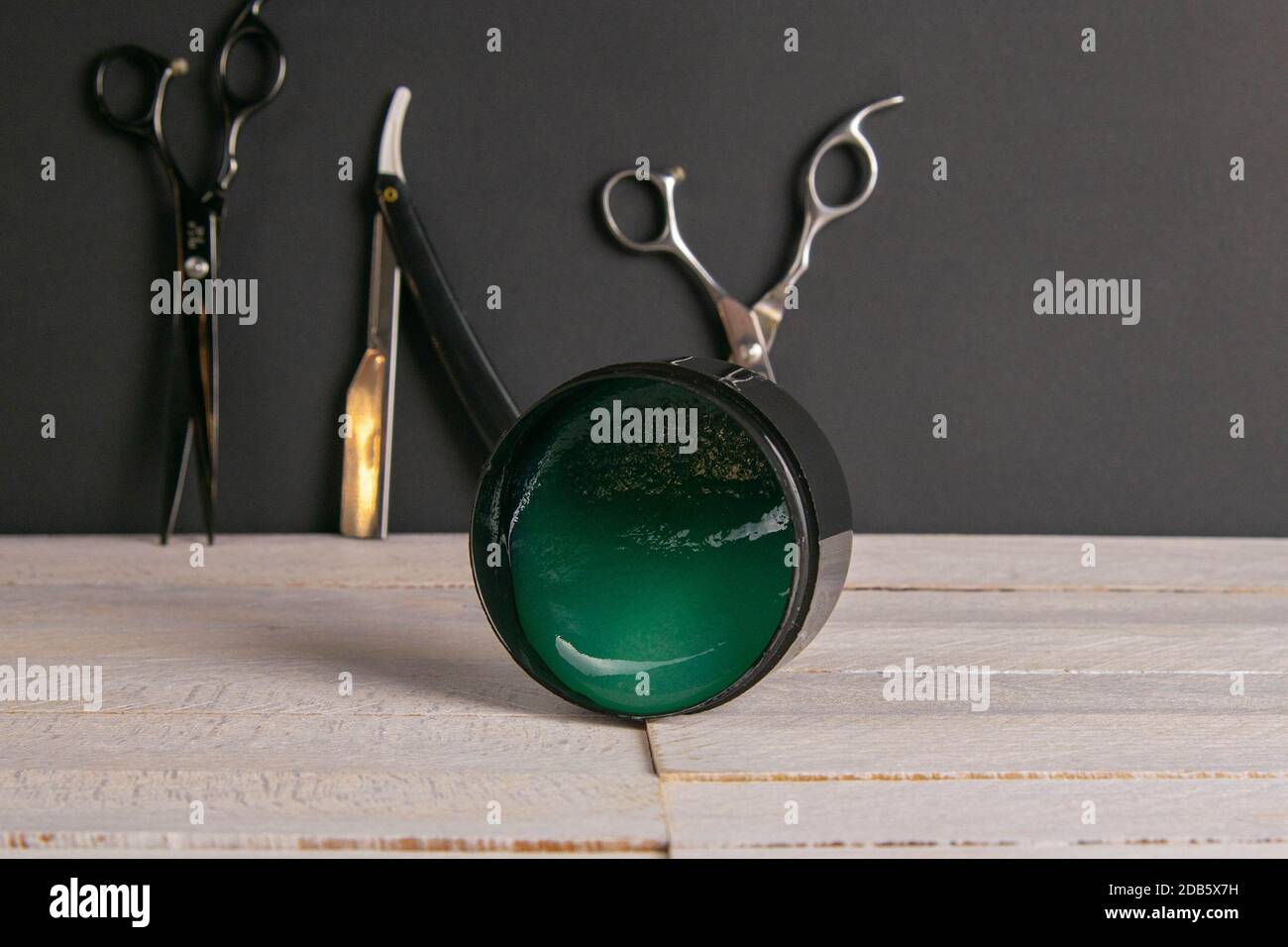Dangerous razor and Scissors, gel for haircuts stand on a wooden table ...