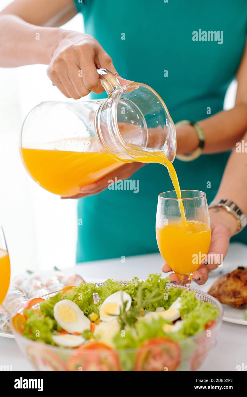Housewife pouring juice in glass Stock Photo - Alamy