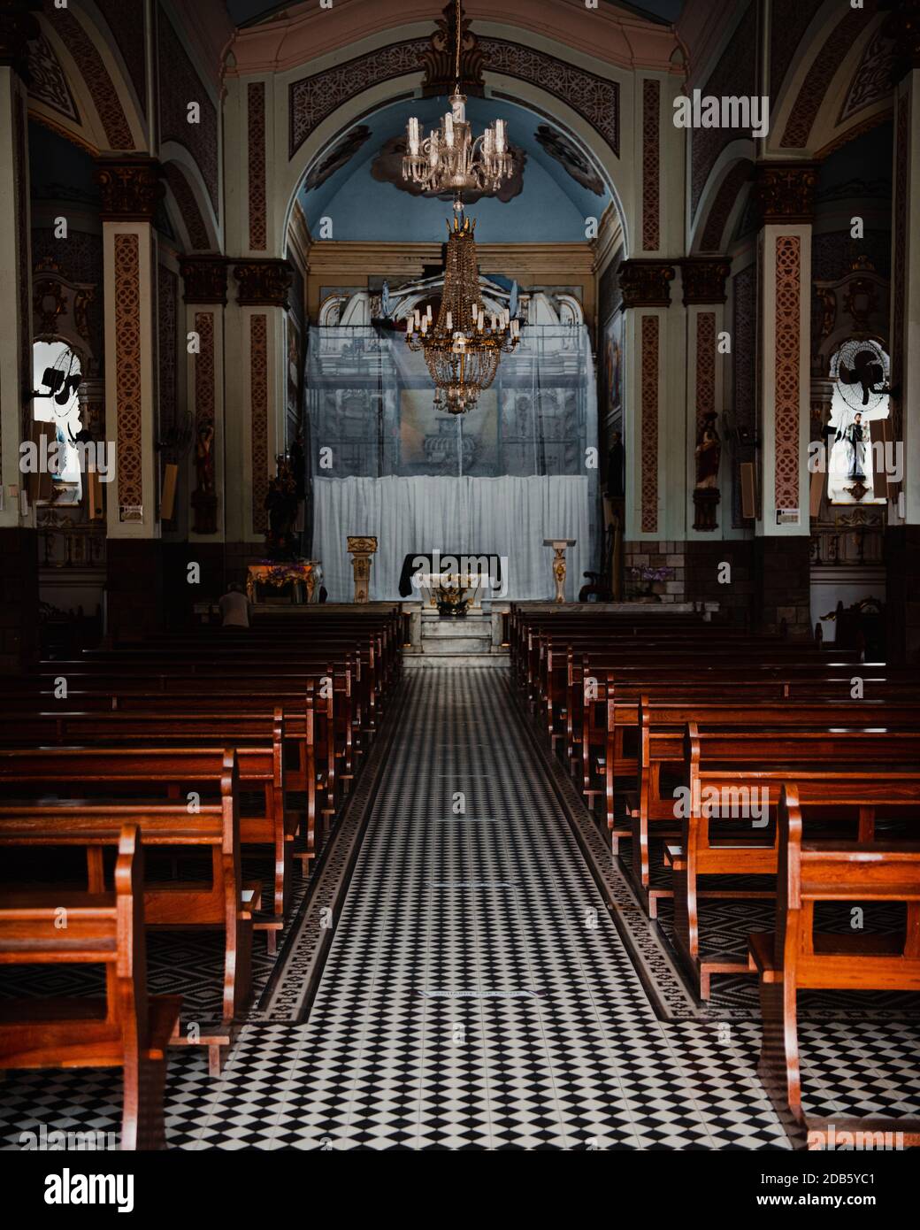 A vertical shot of a historical church interior with empty wooden pews ...