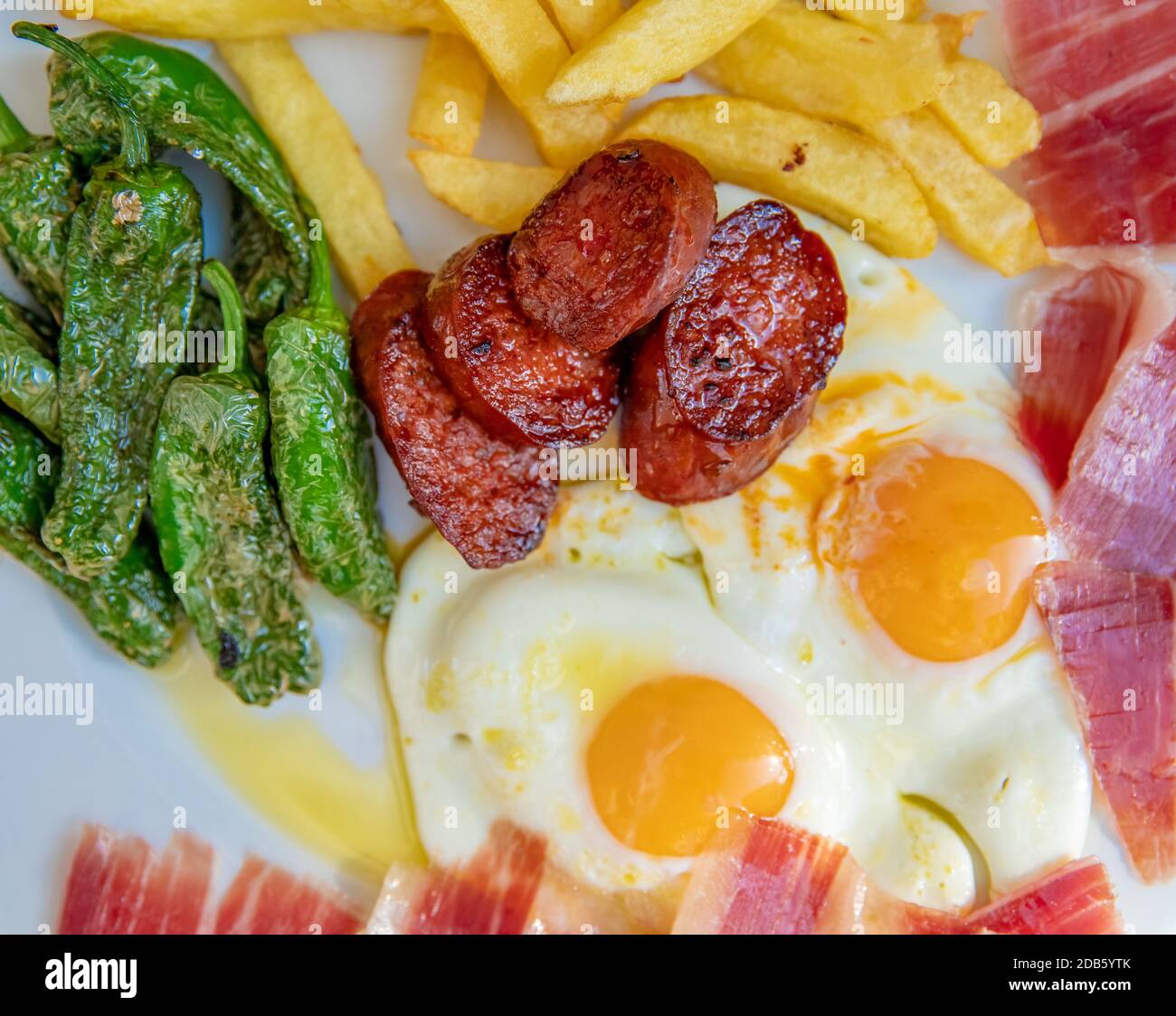 egg with sausage, french fries and vegetable garnish Stock Photo - Alamy