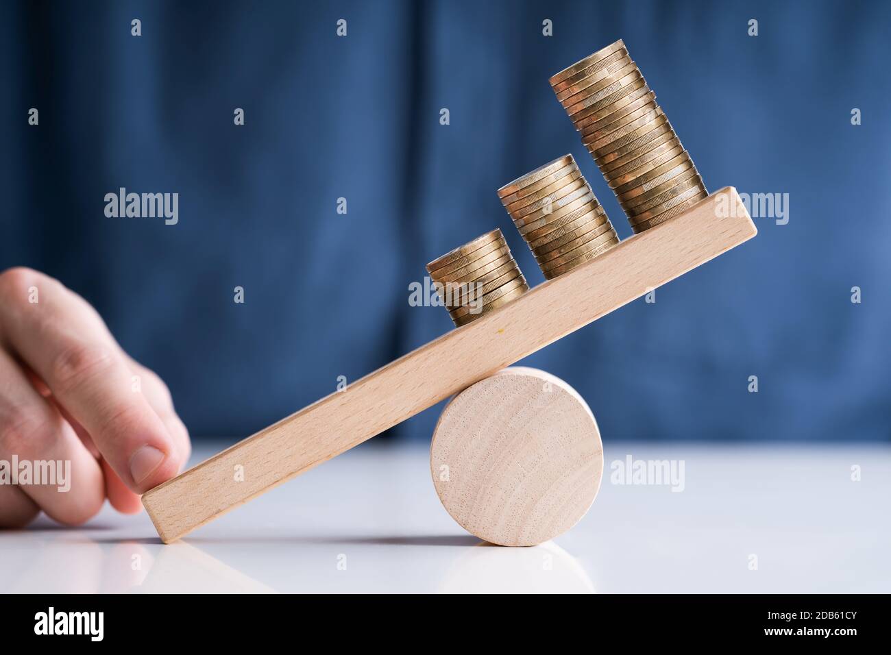 Close-up Of A Businessman Balancing The Coin Stack On Wooden Seesaw ...