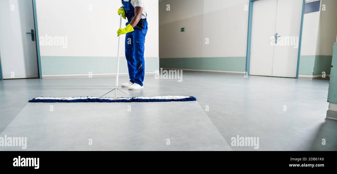 Man With Mop And Wet Floor Sign Stock Photo - Alamy