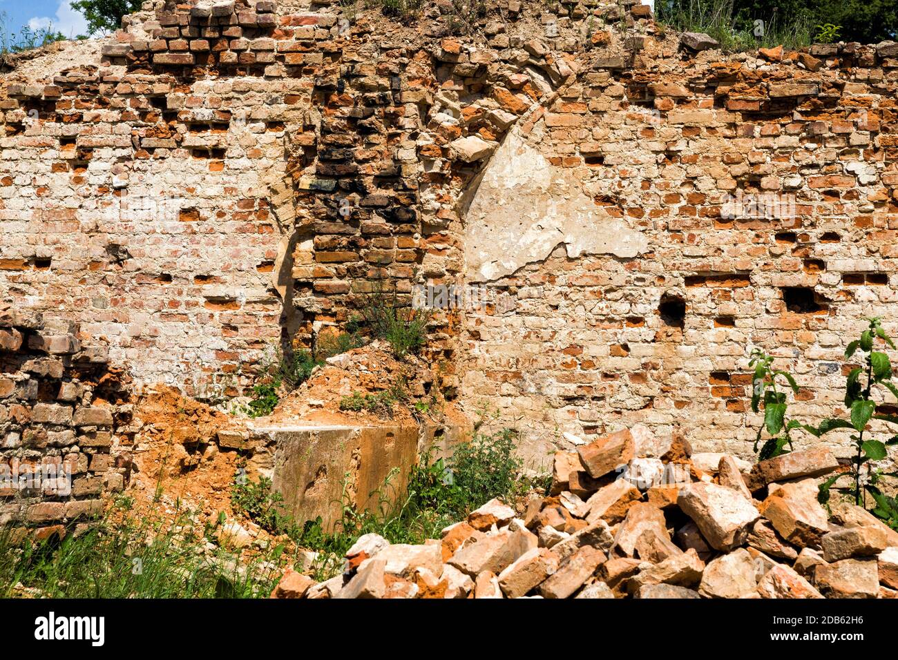 garbage and a pile of red bricks near the ruins of an ancient castle or ...
