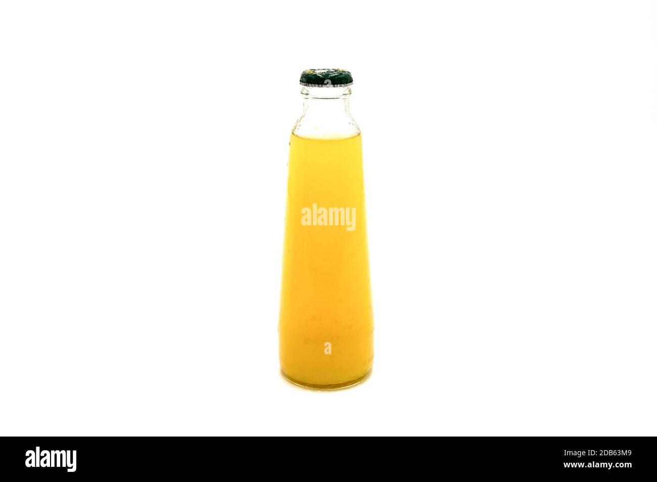 Close up view of fresh pineapple juice in glass bottle on a white ...