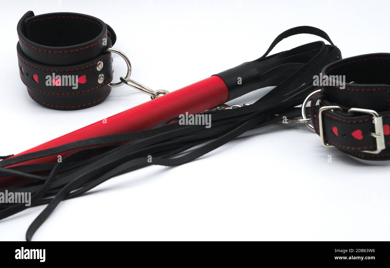 leather handcuffs with chain and ball gag isolated in the white and ...