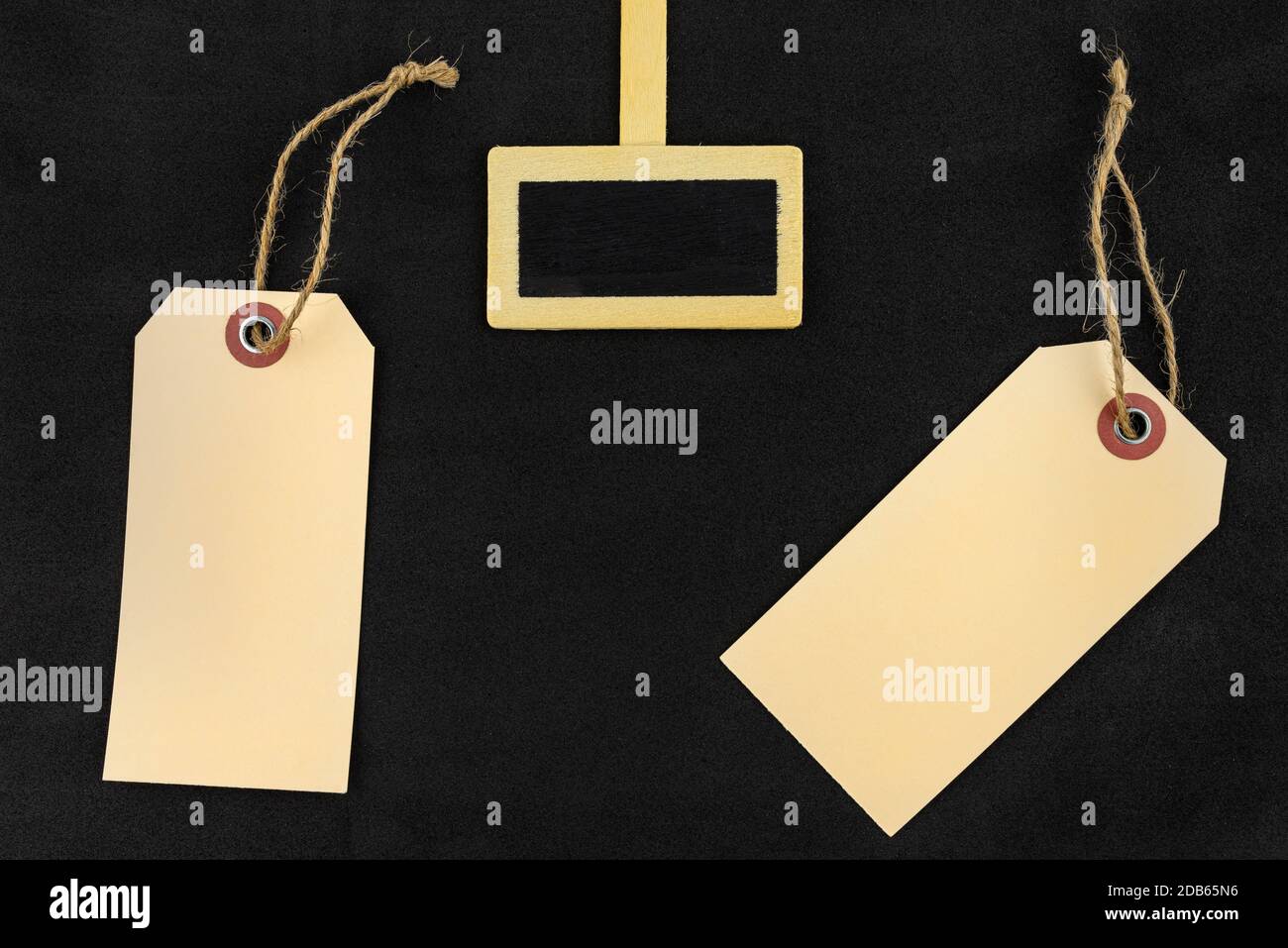 Two blank brown gift tags with a string and a wooden tag on the top ...