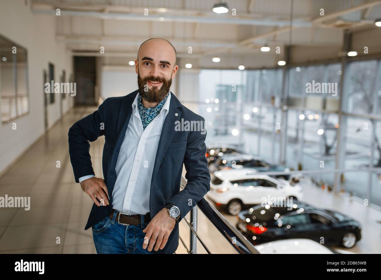 Happy businessman poses in car dealership. Customer in new vehicle ...