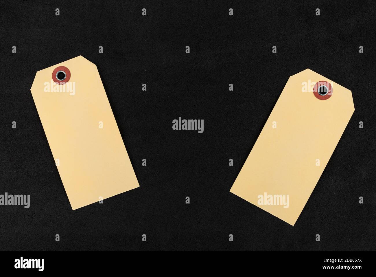 Two blank brown gift tags lying on a black background made of sponge ...
