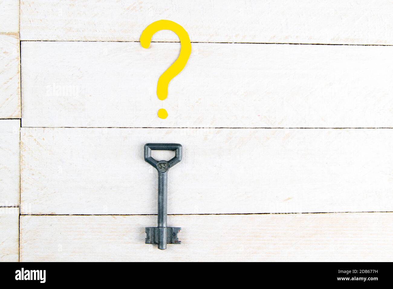 House-shaped key in the wooden table with question mark. Top views ...