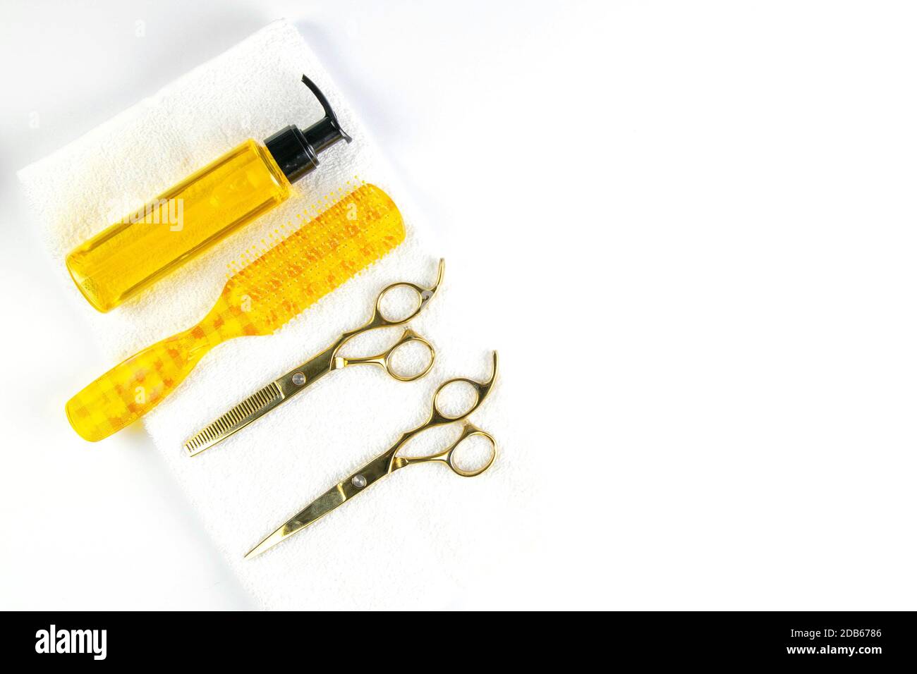 Hair gel, comb and scissors for haircut stand on a white towel which ...