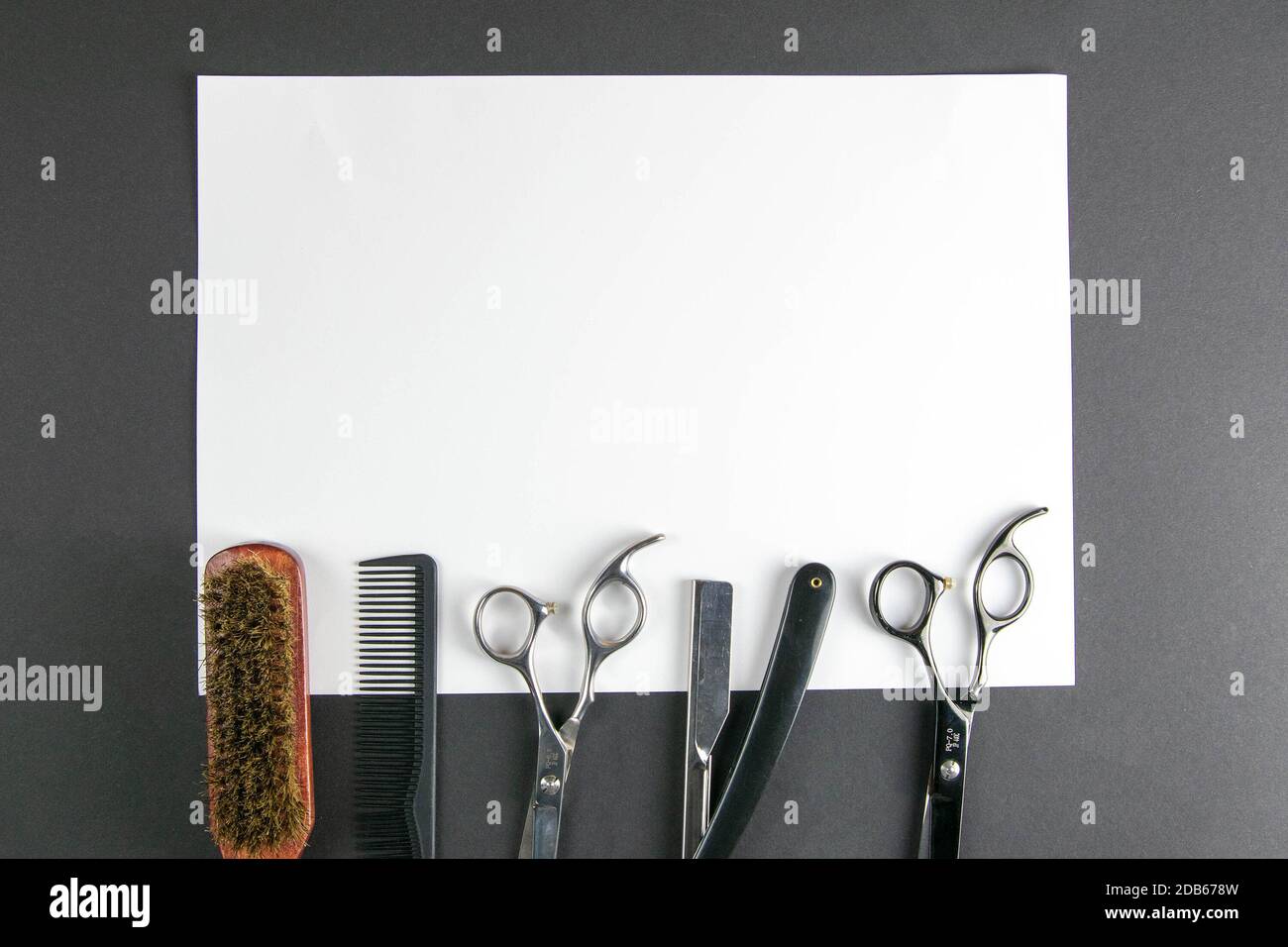 Scissors, hair clipper, combs, dangerous razor on a white sheet on ...