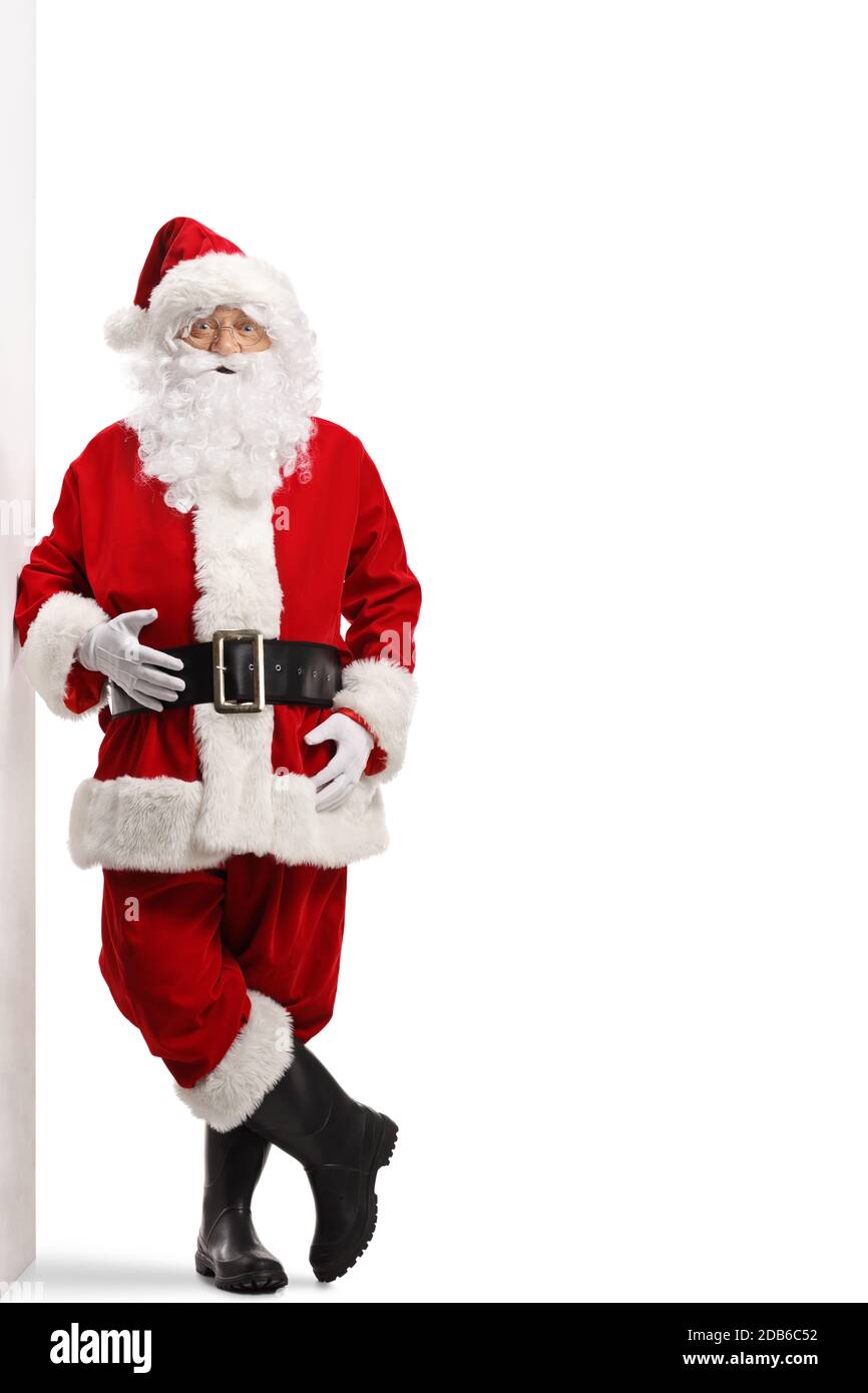 Full length portrait of santa claus leaning on a wall isolated on white ...