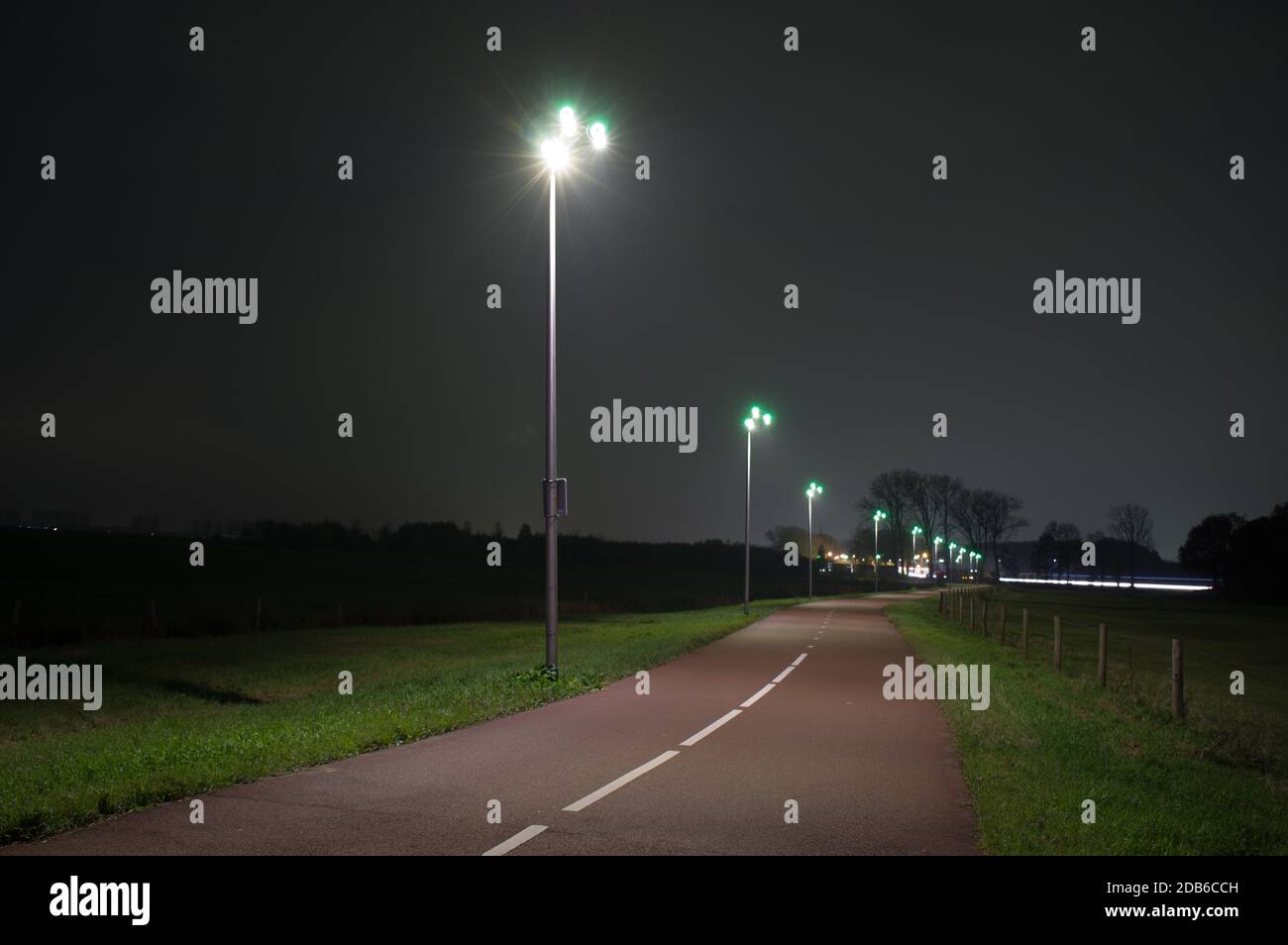 Bicycle path illuminated with green and yellow lights at night Stock ...