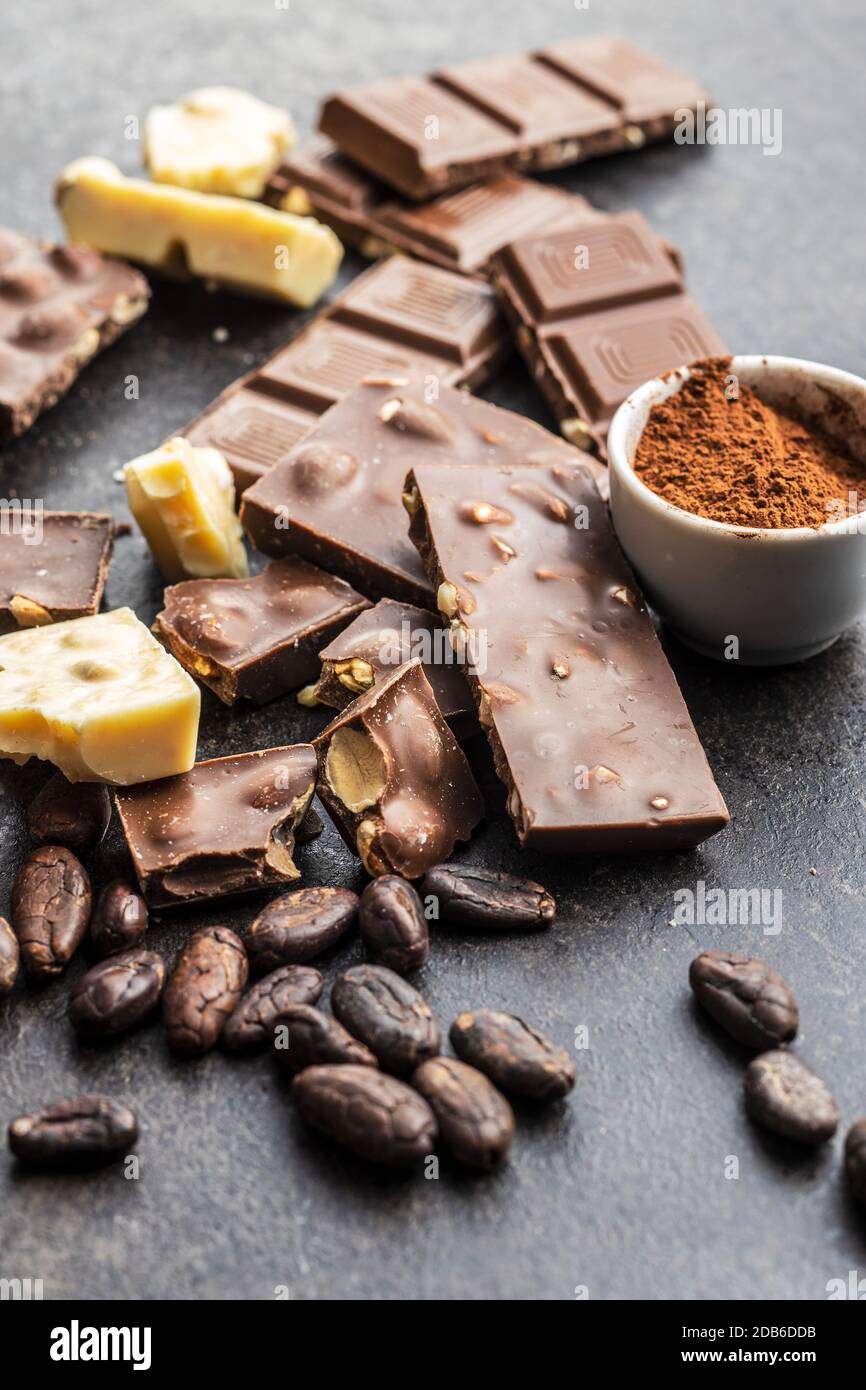 Milk chocolate bars. Dark and white nut chocolate with cocoa powder and ...