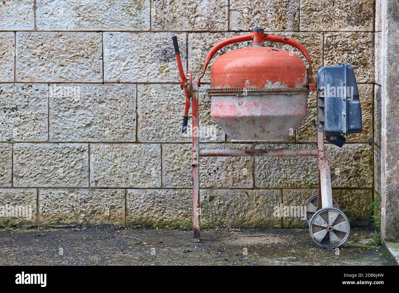 Concrete mixer in front of a stone wall Stock Photo - Alamy