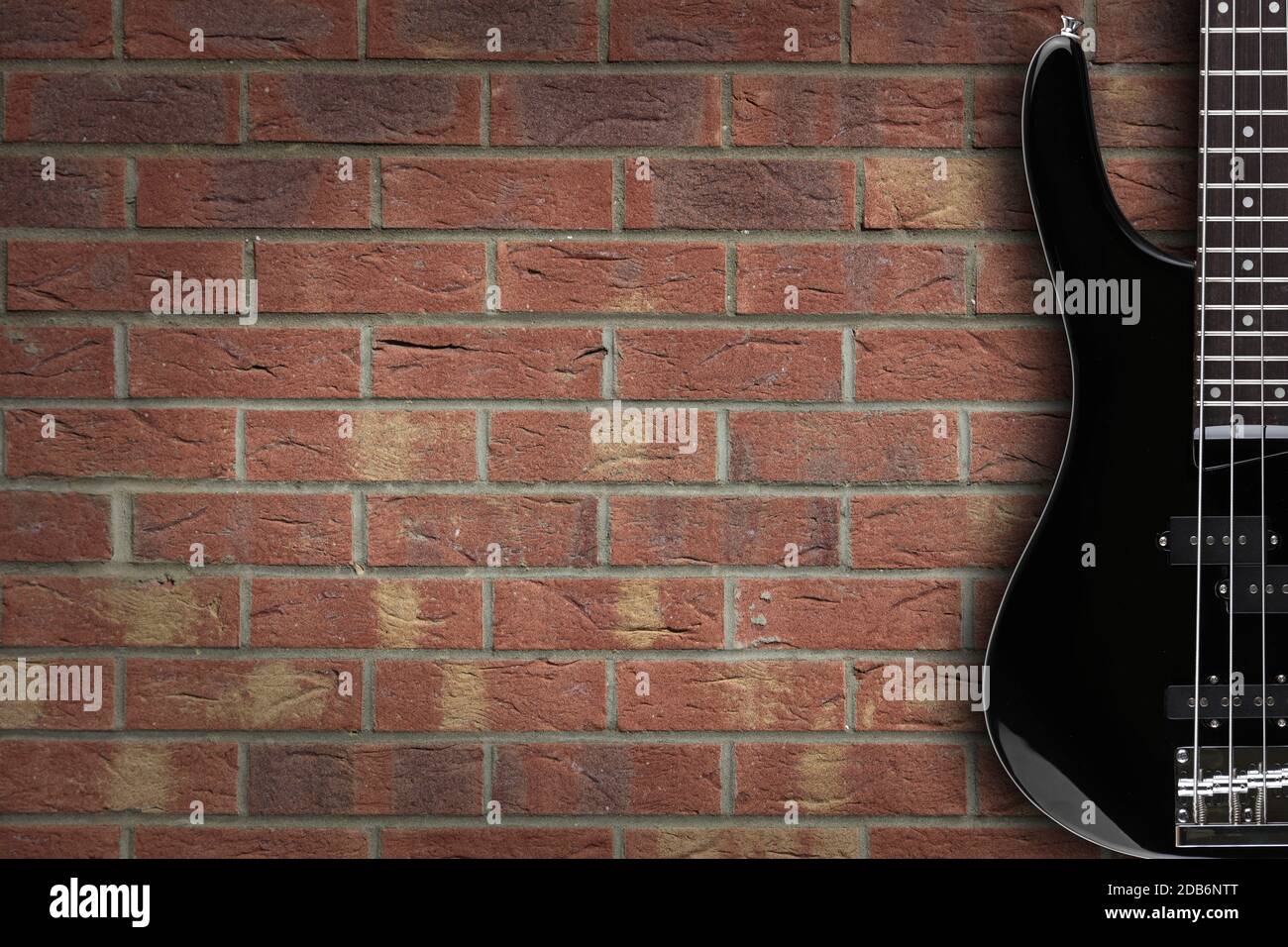 A bass guitar on brick background with copy space Stock Photo - Alamy