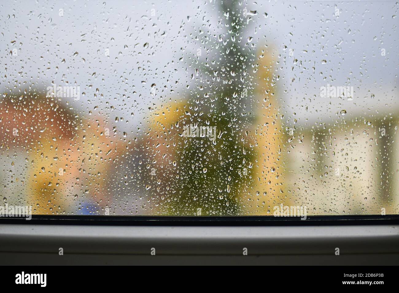 Urban view of rain drops falls on a window during a stormy day Stock ...