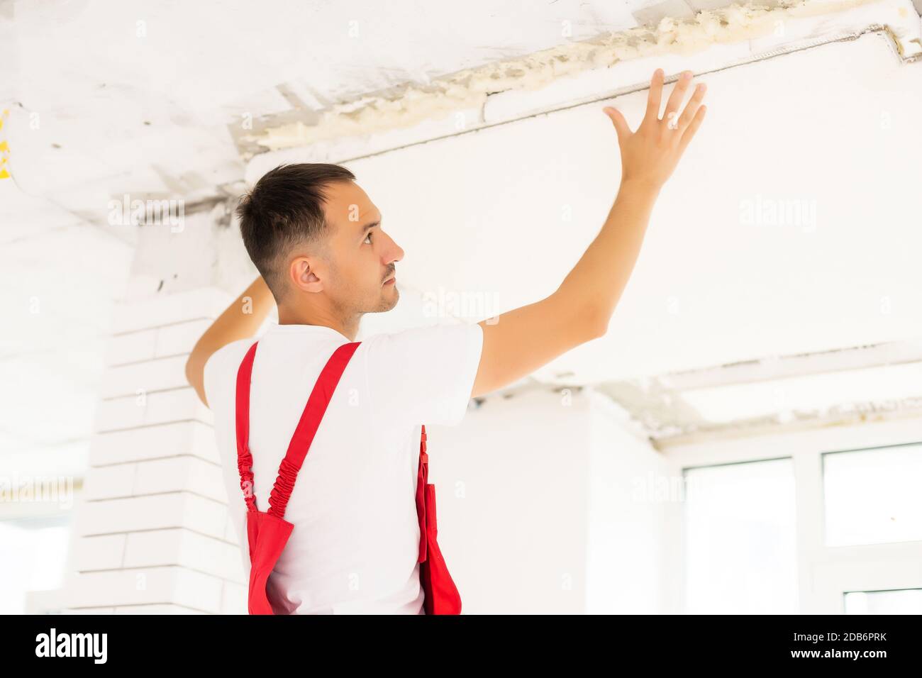 Young man fixing ceiling insulated. Renovation, construction Stock ...