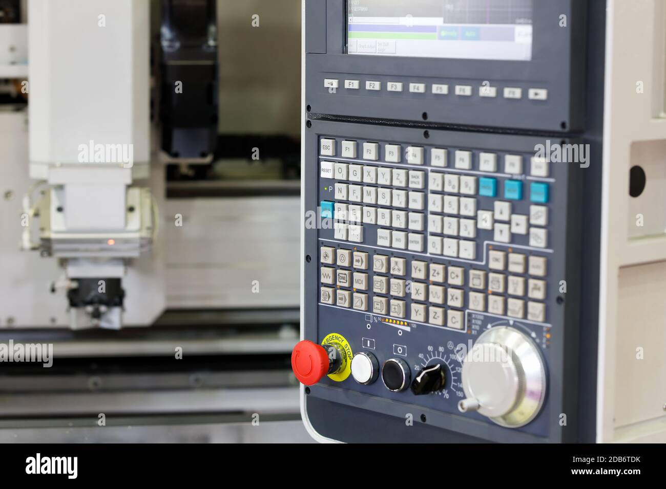 Modern machining center with CNC control panel in the foreground ...