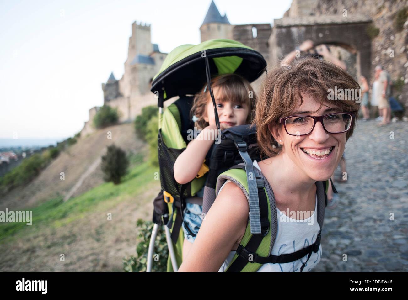 Female tourist with daughter in baby carrier, Carcassonne, Aude, France ...