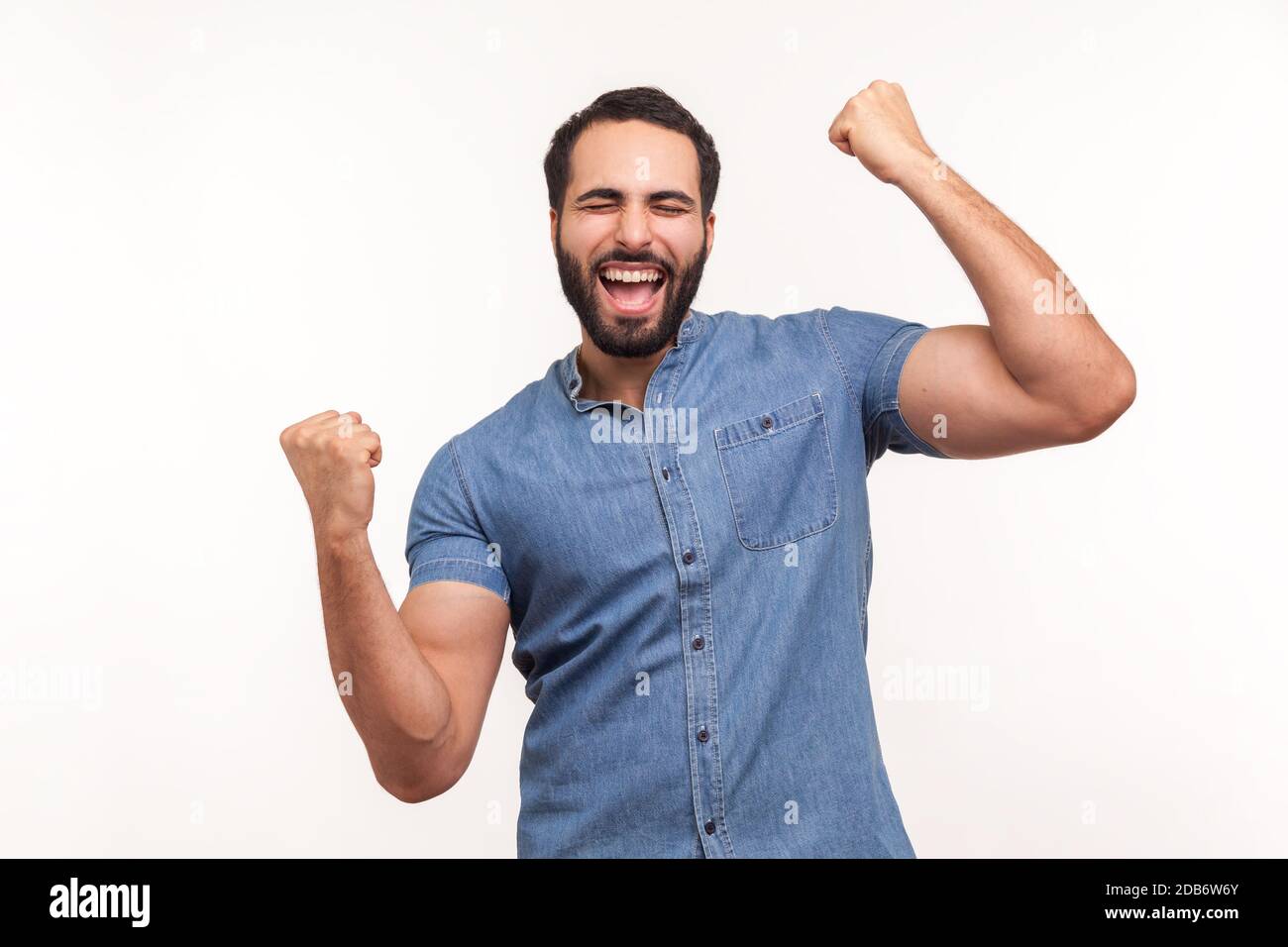 Euphoric thrilled man with beard screaming hurray raising hands up ...